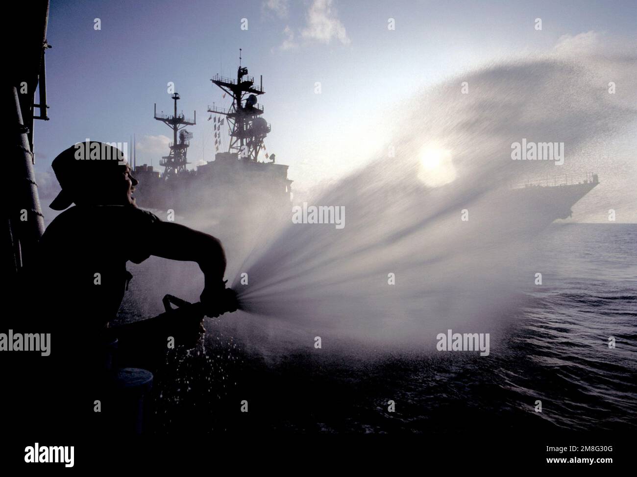 A sailor aboard the guided missile destroyer USS DAHLGREN (DDG-43) aims ...