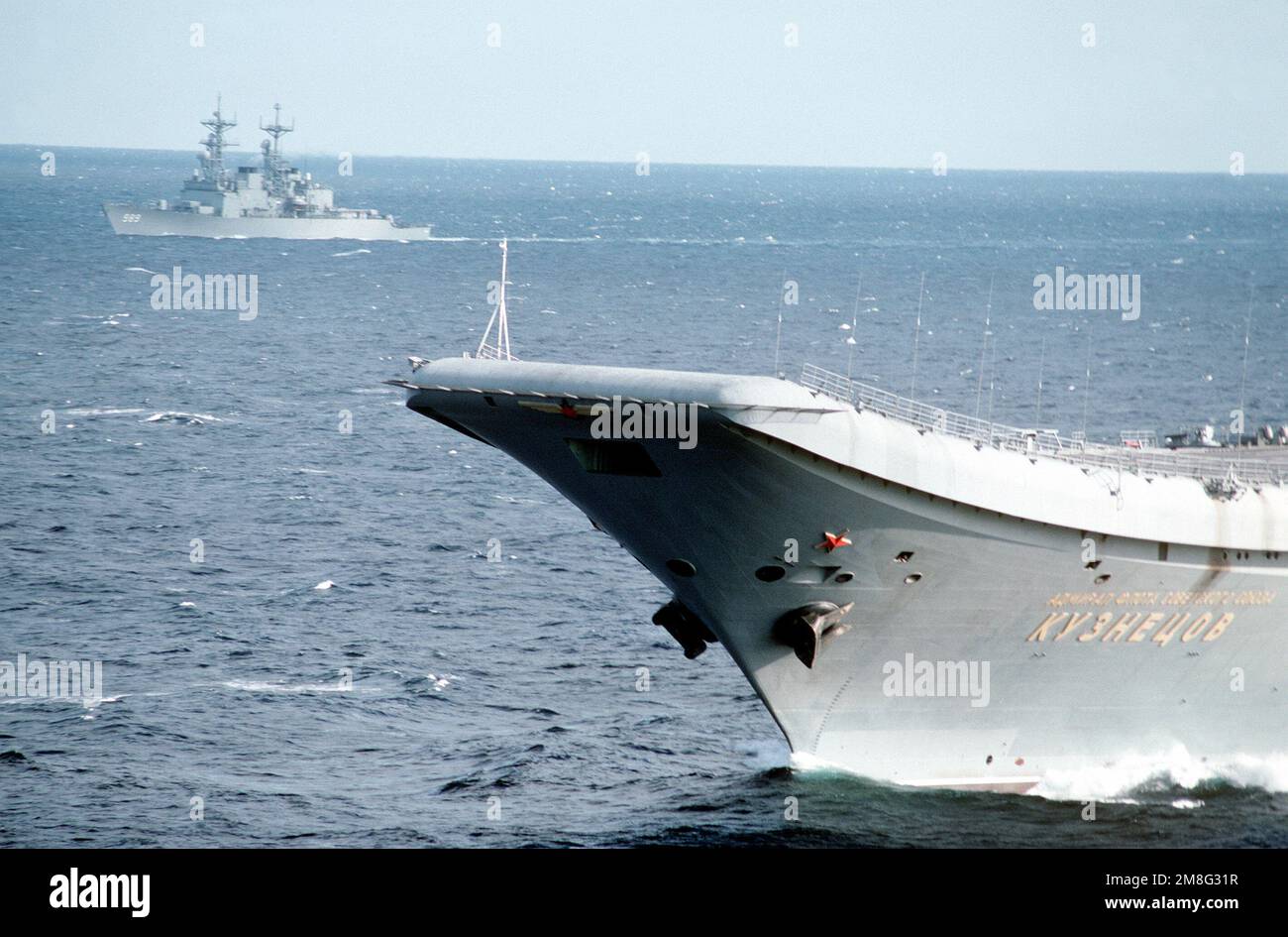 The destroyer USS DEYO (DD 989) background, steams off the starboard ...