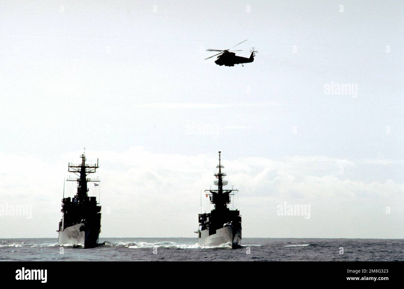 An SH-2F Seasprite helicopter flies over the destroyer USS O'BANNON (DD ...