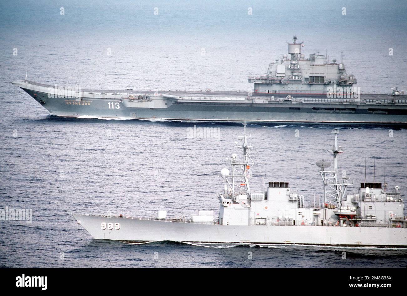 The destroyer USS DEYO (DD 989), foreground, steams off the port side ...