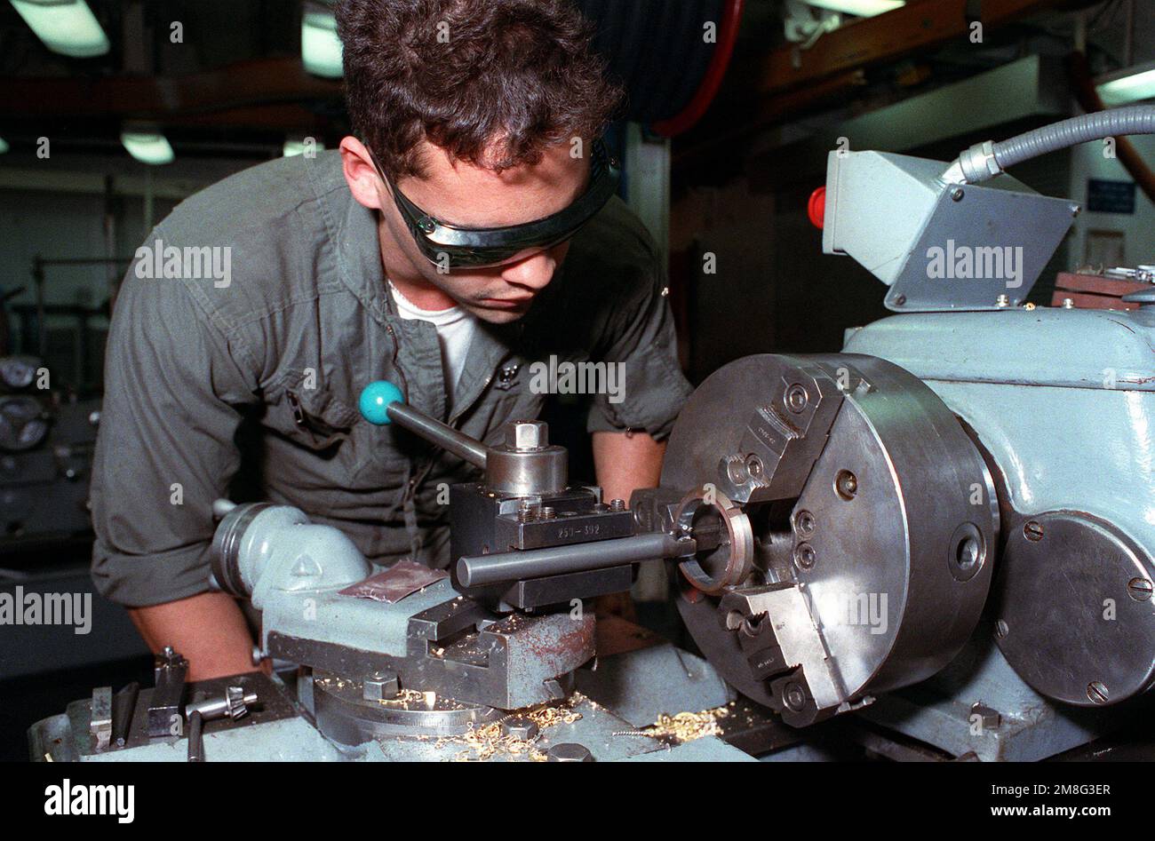 Machinery Repairman 3rd Class Keith M. Crider uses a lathe to make a ...