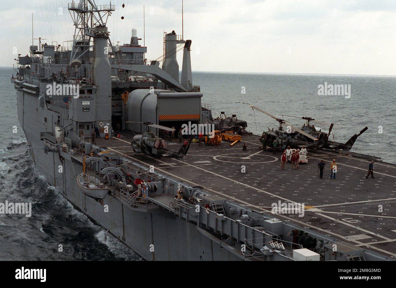 AH-1 Sea Cobra helicopters and a UH-1 Iroquois helicopter stand on the ...