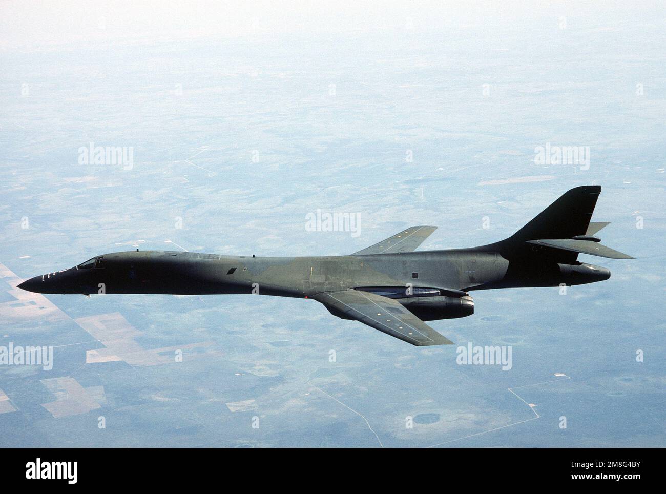 An air-to-air left side view of a B-1B bomber aircraft. Country ...