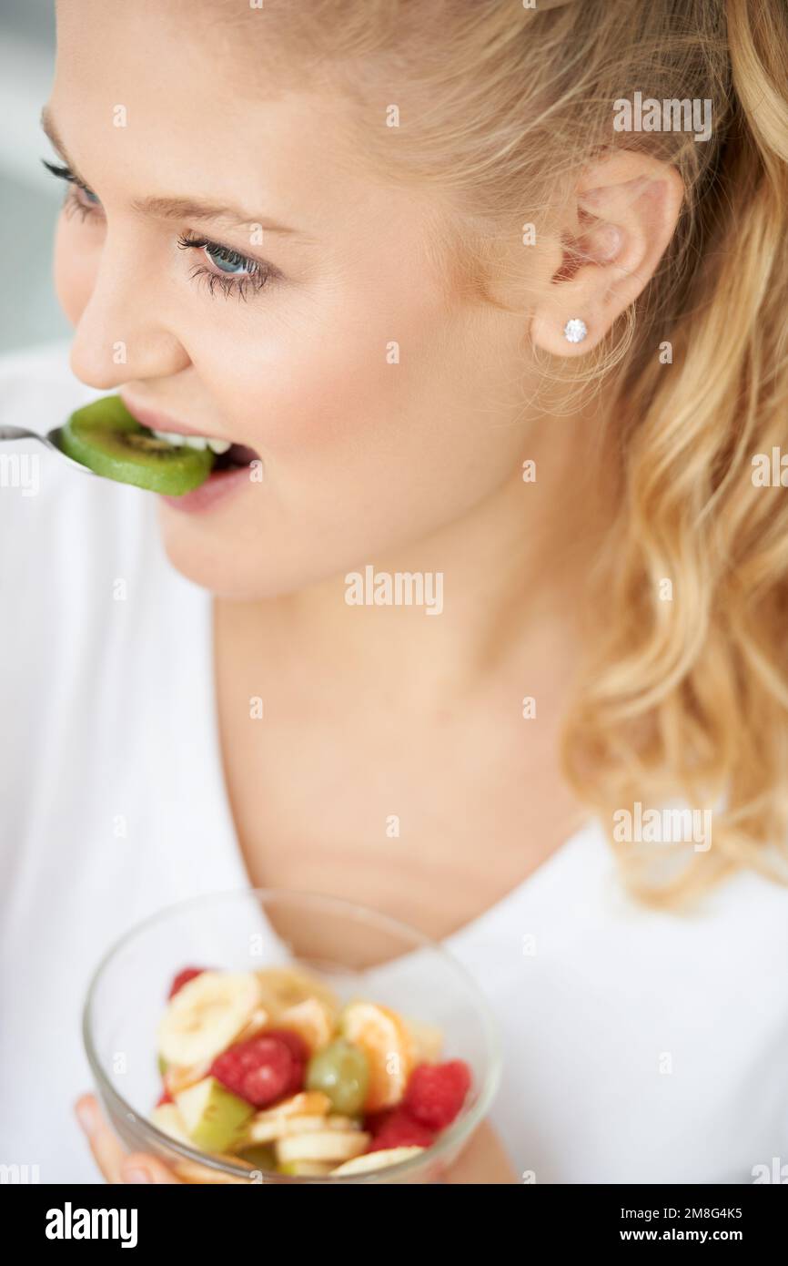 Enjoying a vitamin-packed snack. Closeup of an attractive young woman ...