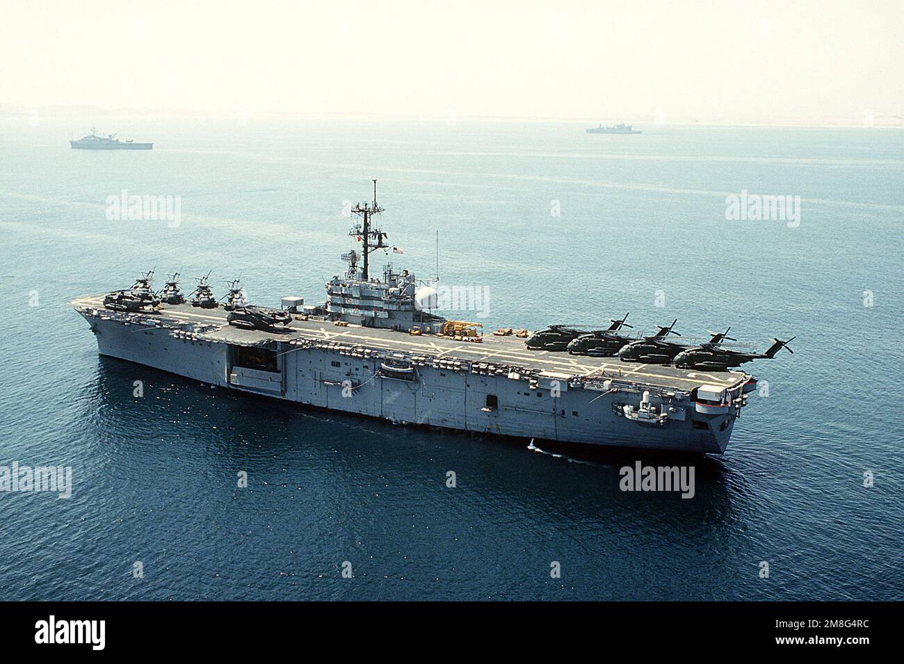 Various helicopters line the deck of the amphibious assault ship USS ...