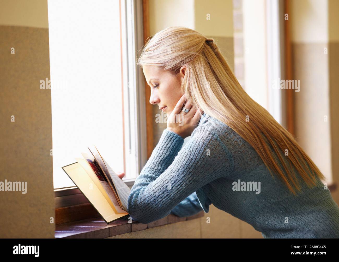 Enjoying her reading assignment. A gorgeous young teacher reading a ...