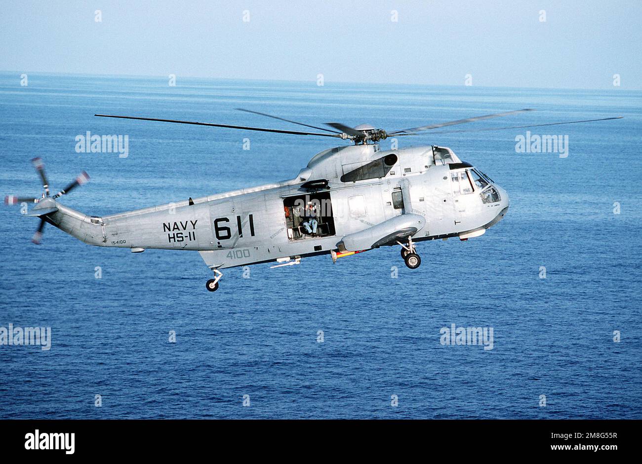 A photographer aims his camera from the open door of a Helicopter Anti ...
