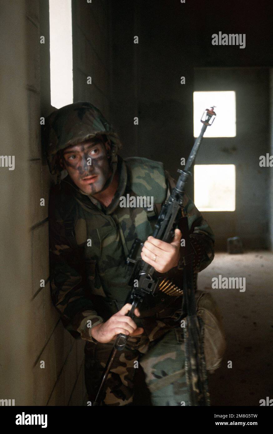 A Marine moves cautiously through a building in combat town, a mock ...