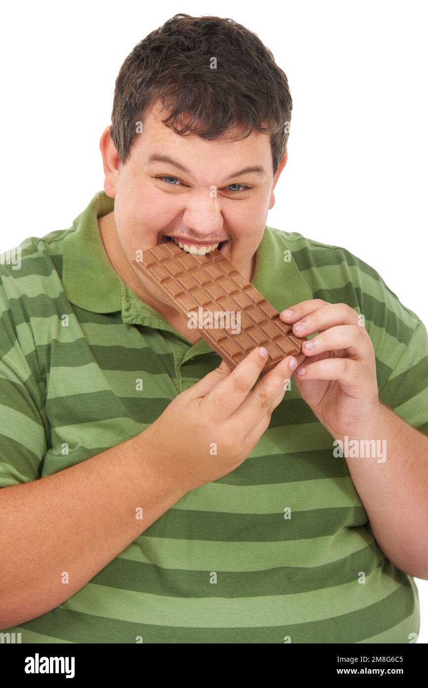 Chomping on his chocolate. An obese young man biting into a slab of ...