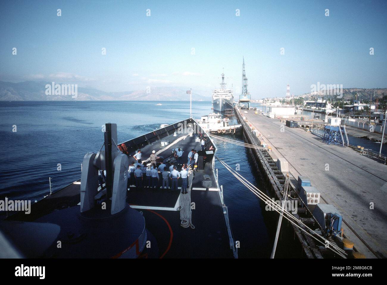 Crew members gather for a briefing on the bow of the guided missile ...