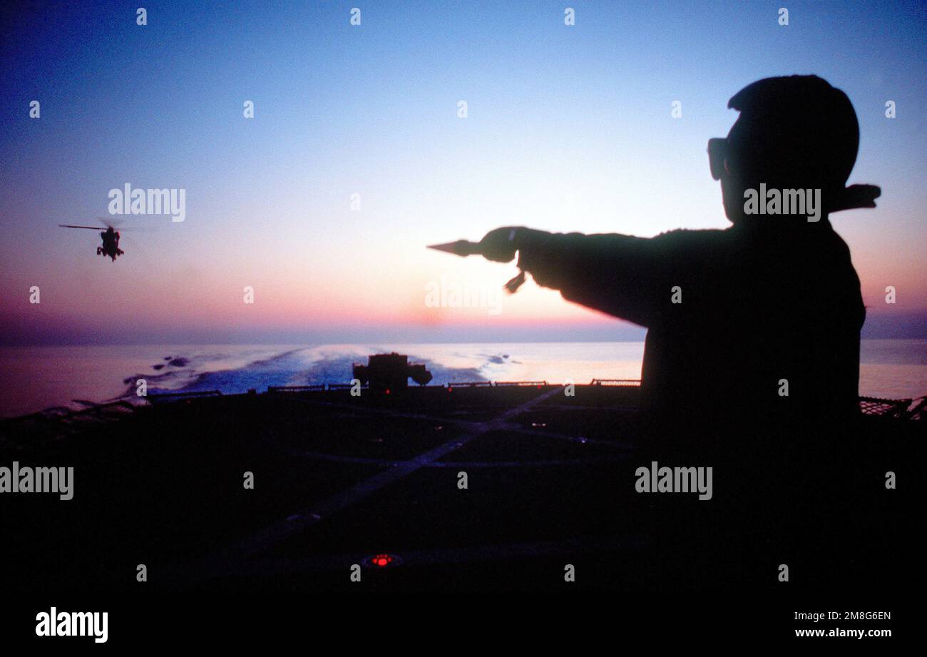 A plane director on the heli-pad of the guided missile destroyer USS ...