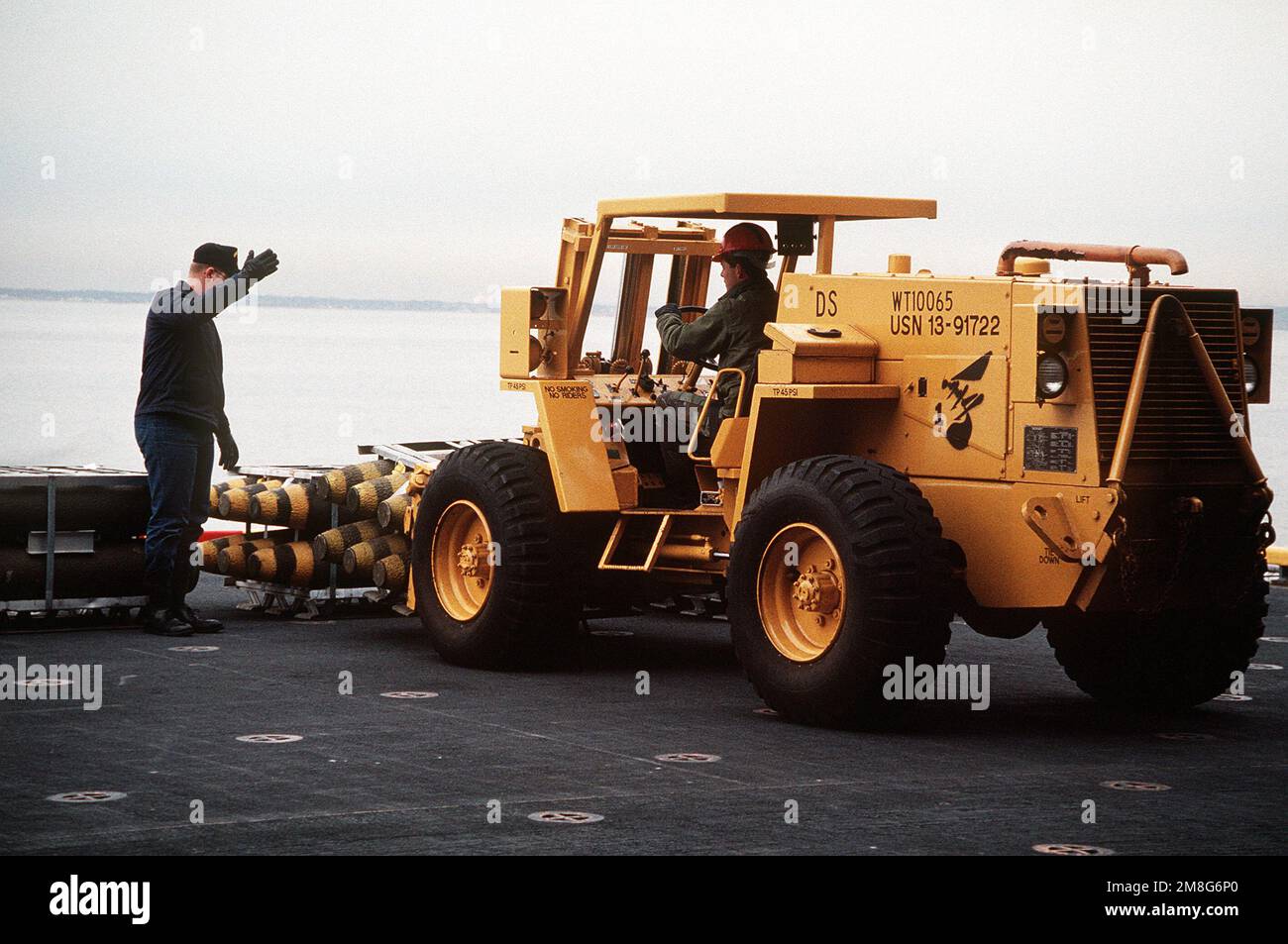 An ordnanceman uses a forklift to move pallets of 500-pound bombs ...