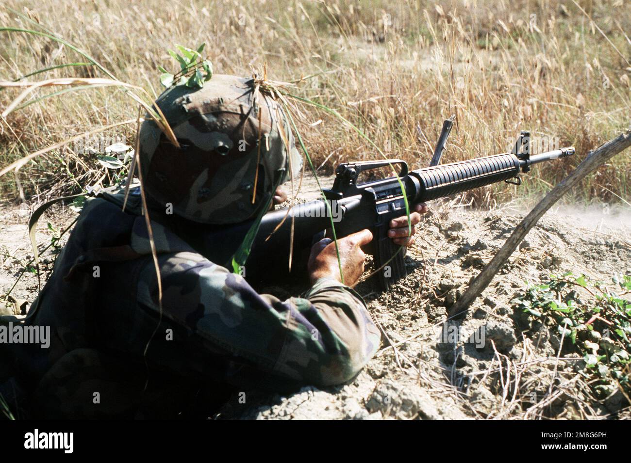 A Marine aims an M-16A2 rifle as he guards the perimeter between the ...