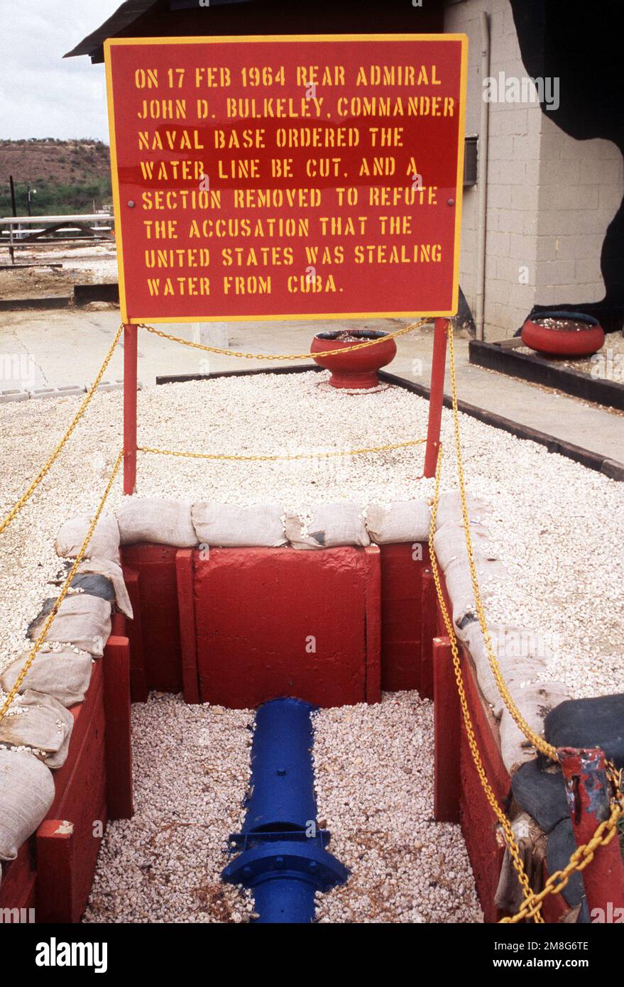 A sign stands above the severed water line that once connected the base ...