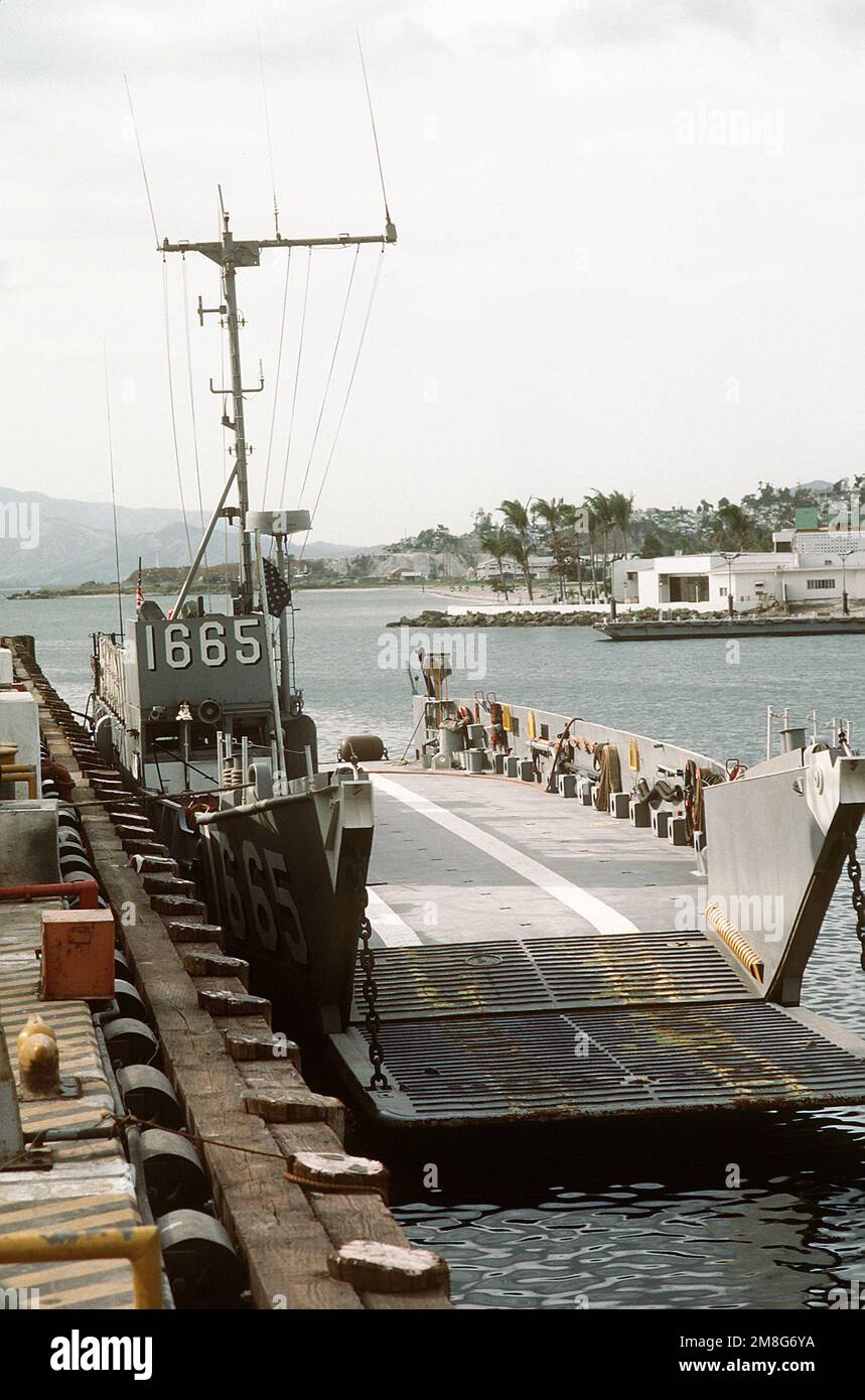 Utility landing craft LCU-1665 is tied to a pier. Base: Naval Station ...
