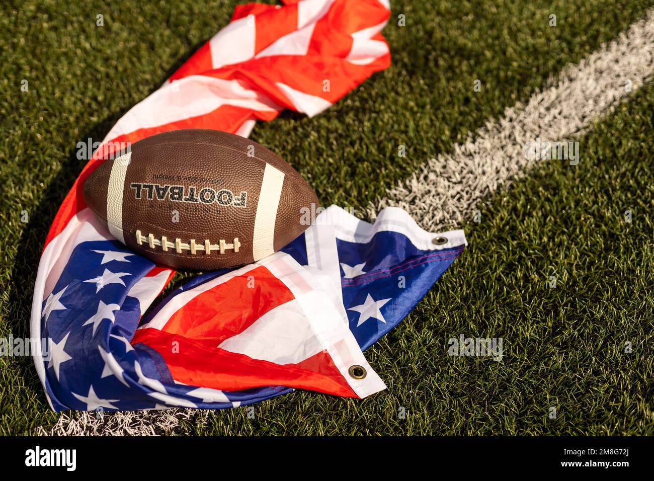 American football on green grass, on flag of United States of America ...
