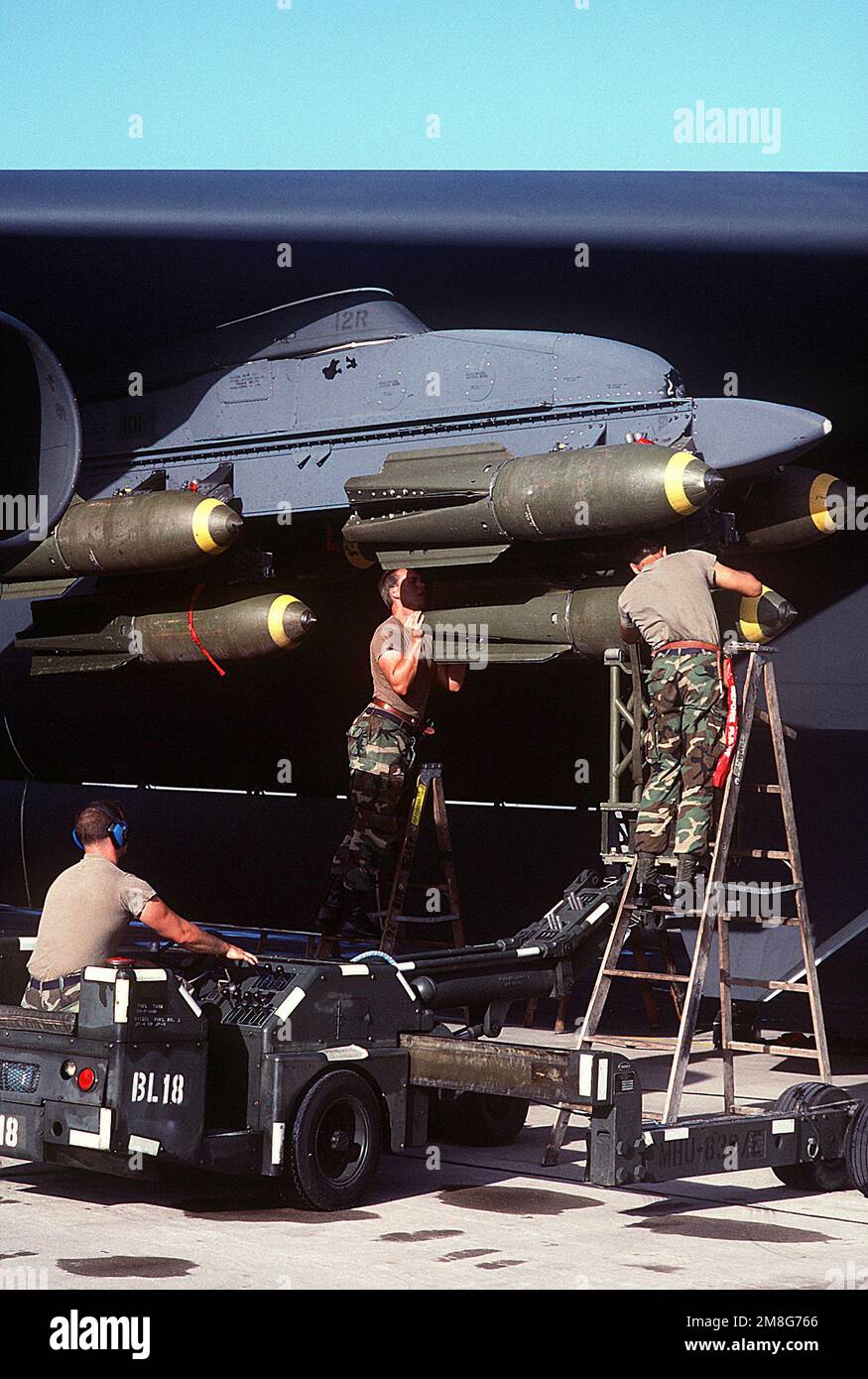 Ordnancemen use an MJ-1 bomb loader to load Mark 117 750-lb. bombs on a ...