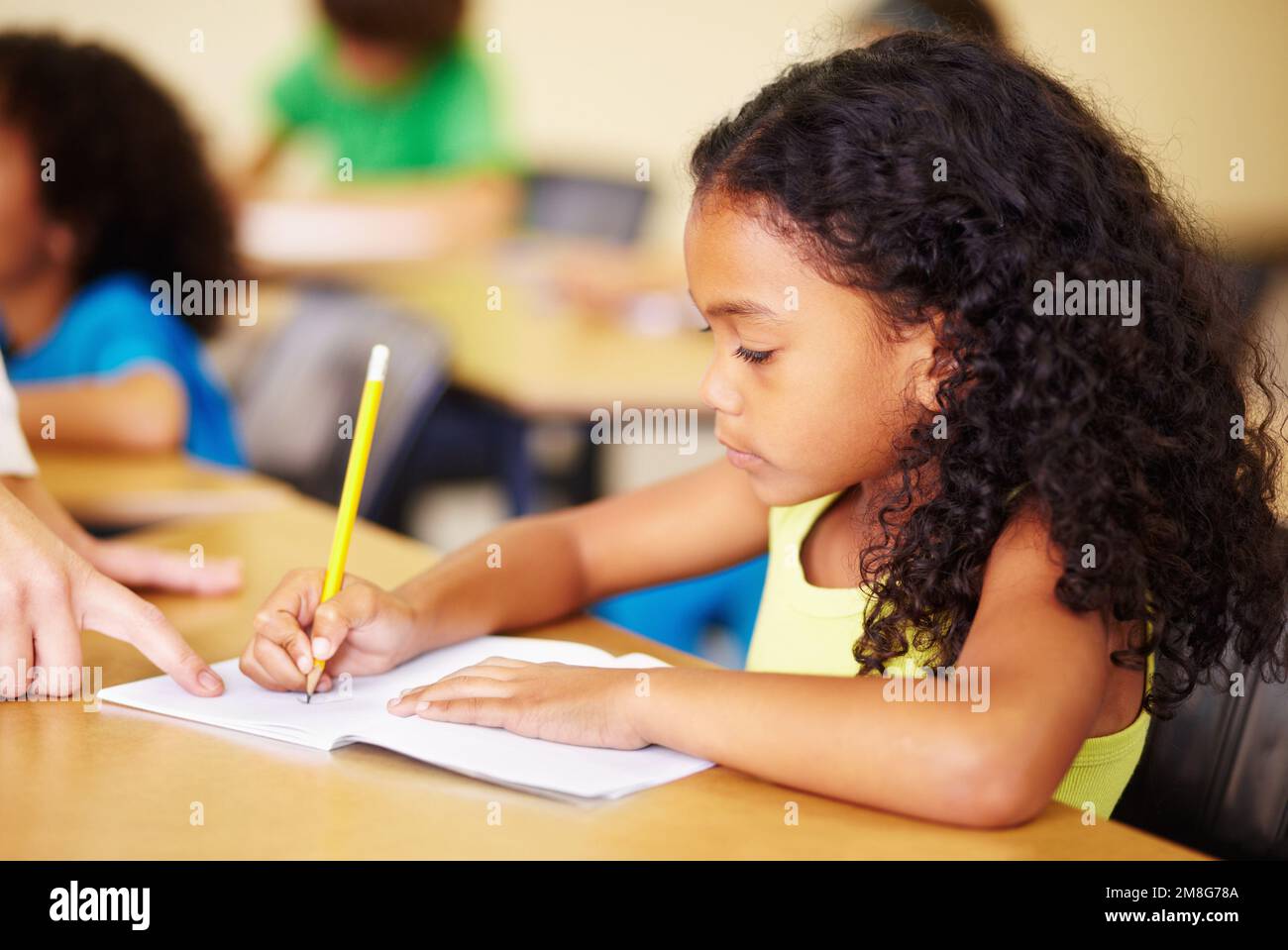 Now she knows how to do it. A little girl doing her homework in class ...