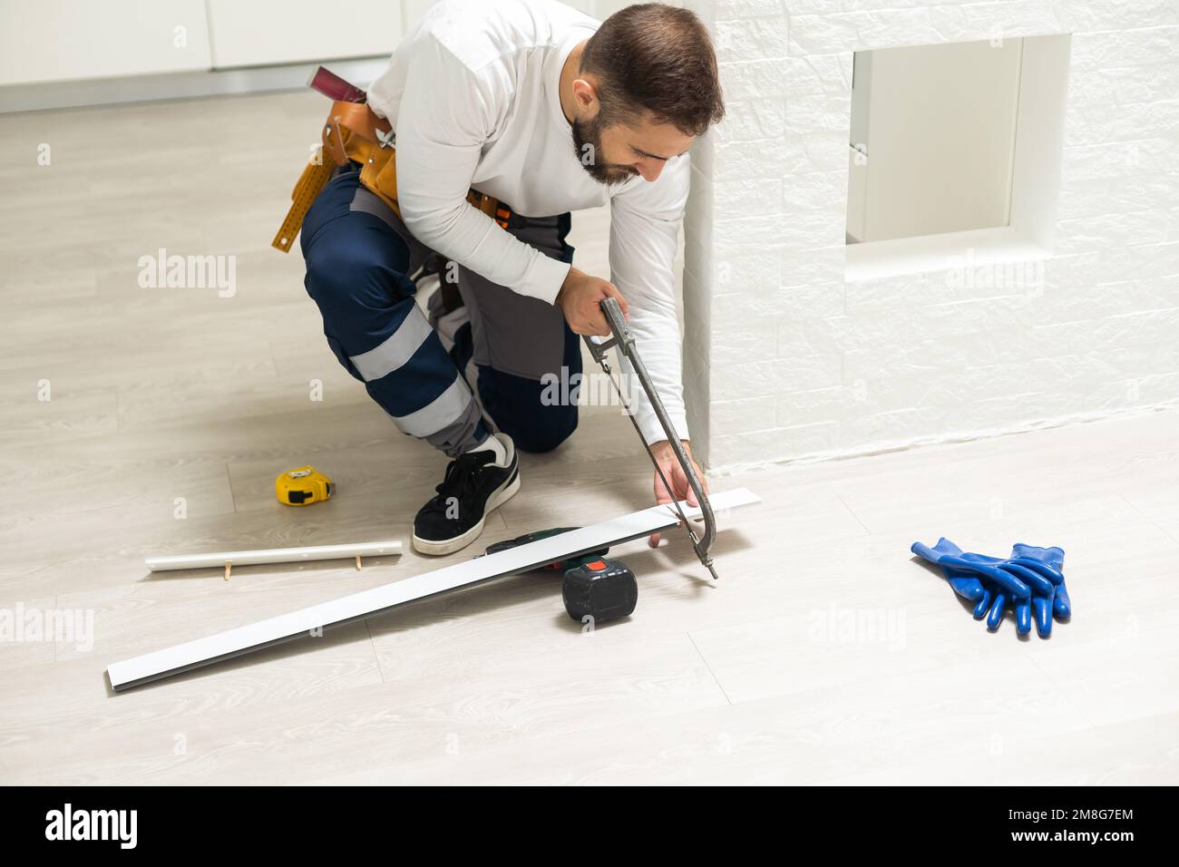 The craftsman measures the length of the plinth for cutting, installing ...