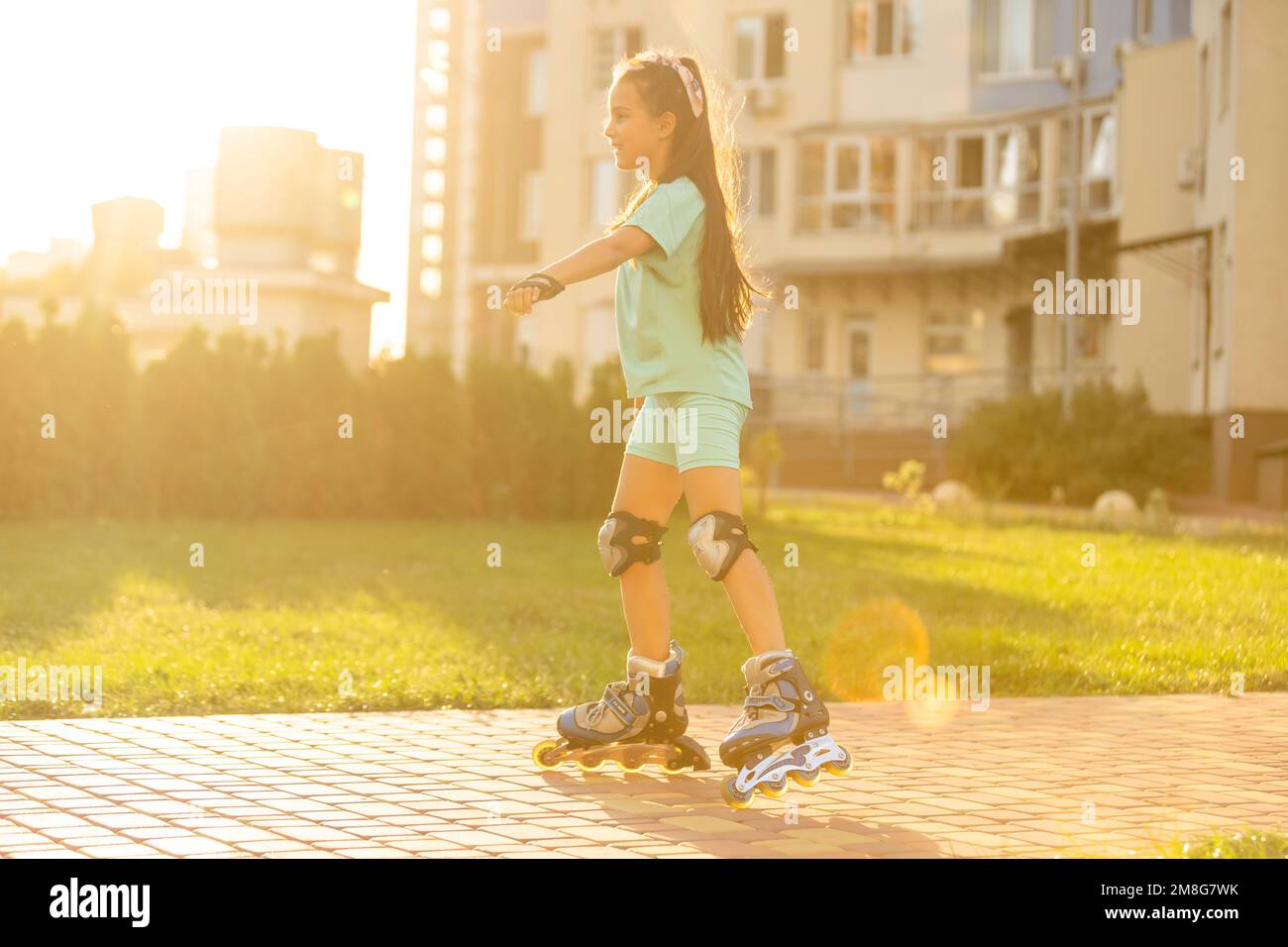 little cute happy girl rollerblading through the city streets Stock ...