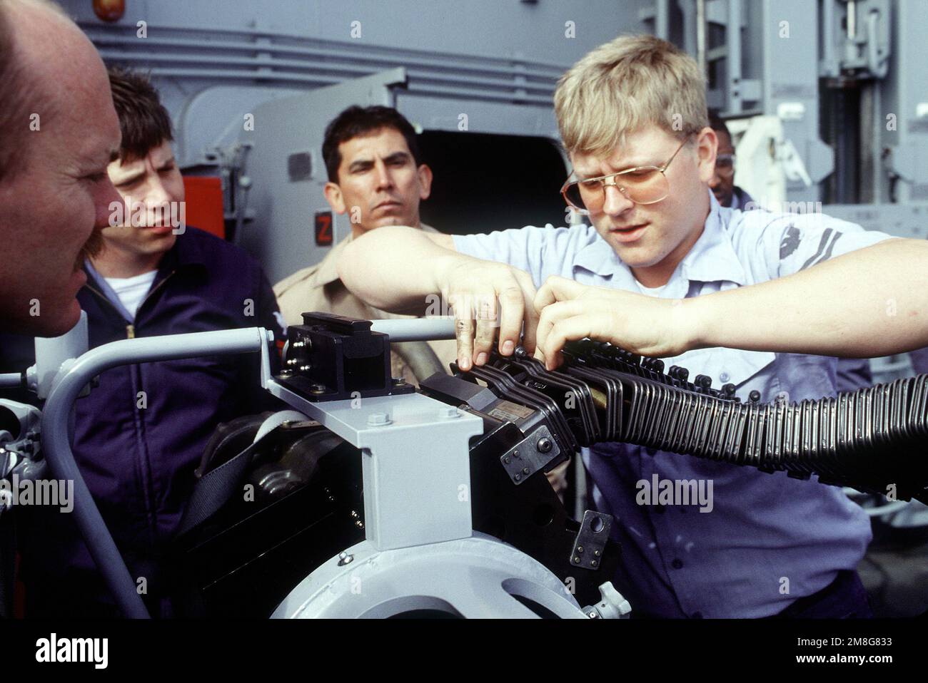 Gunners Mate Second Class (GMG2) Hightower makes an adjustment to the ...