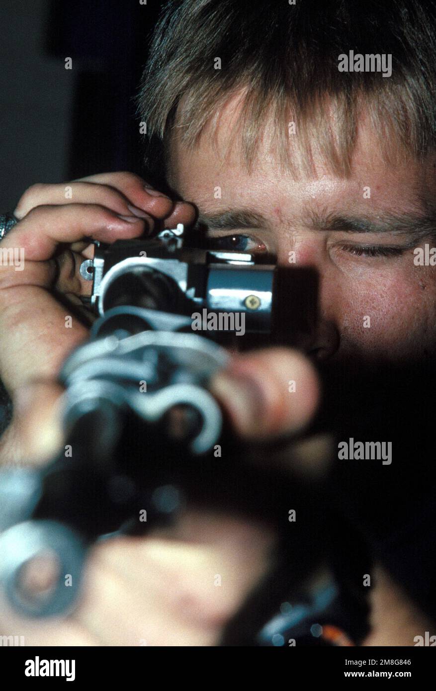 A gunner's mate at the armory is shown bore-sighting an M-14 rifle in ...