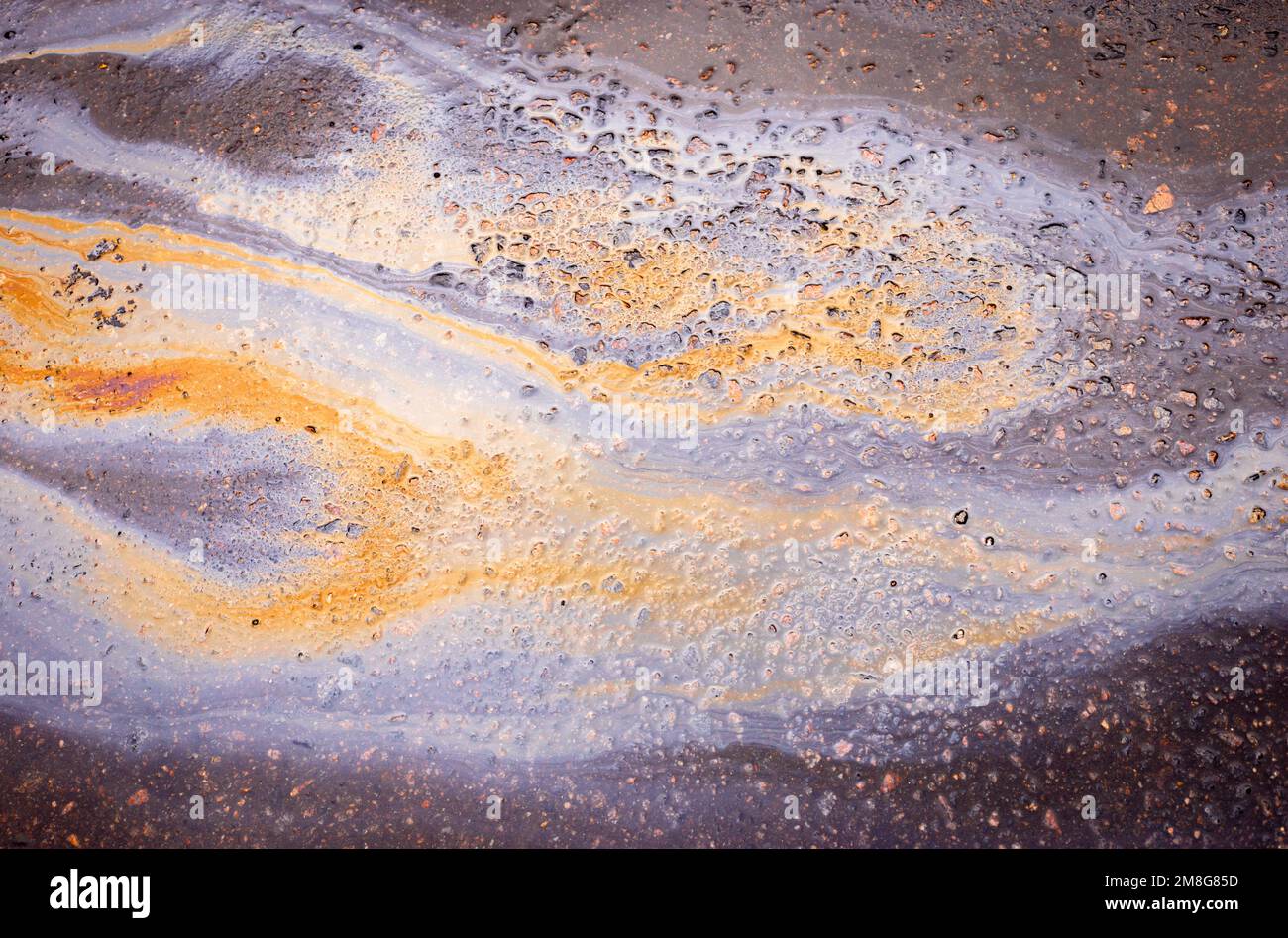 Oil stain on the asphalt, rainbow-shaped colored gasoline stains on an ...