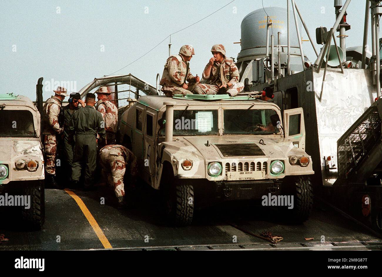 Marines take a break atop an M-1038 cargo/troop carrier as it is ...