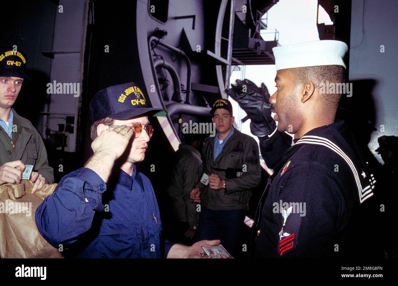 A petty officer checks identification of crew members coming aboard the ...