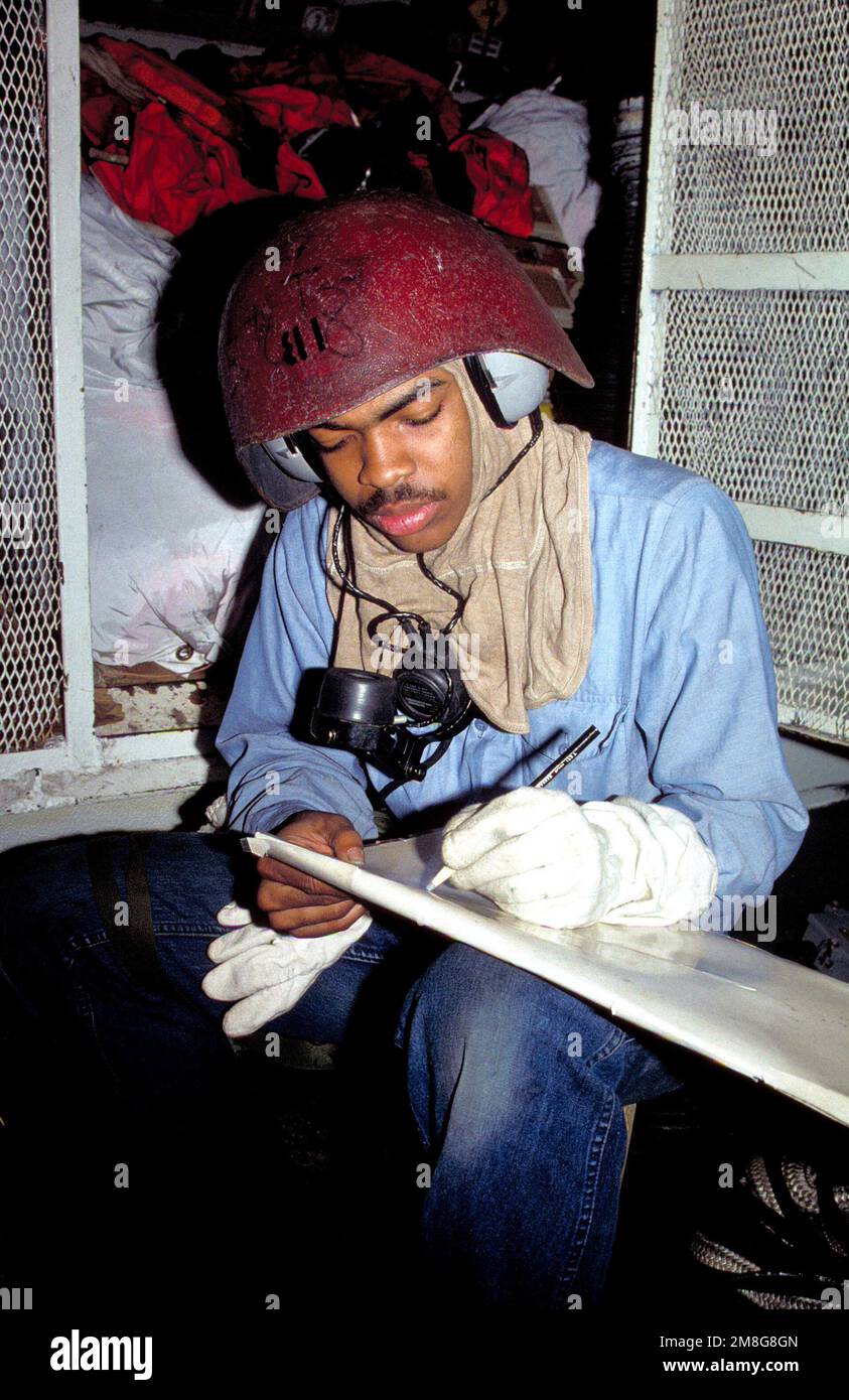 A sailor makes notations on a damage control chart during a general ...