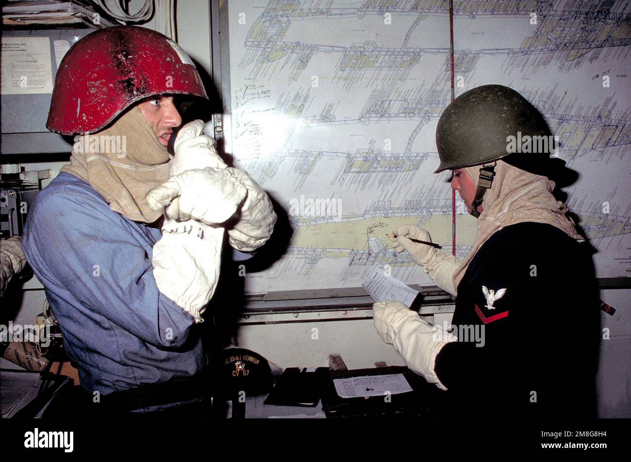 A sailor conveys information as a petty officer makes notations on a ...