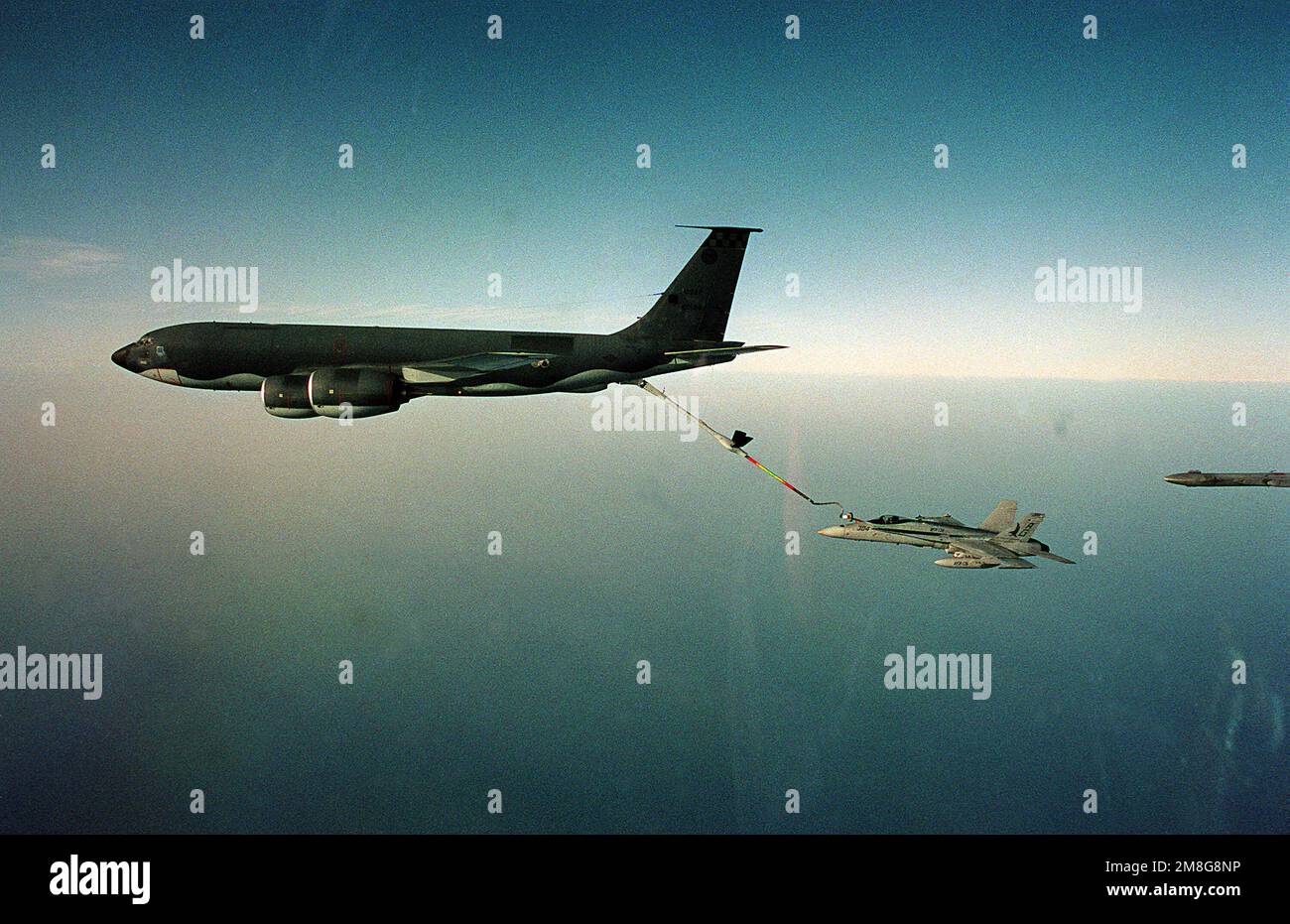 A KC-135R Stratotanker aircraft refuels a Strike Fighter Squadron 136 ...