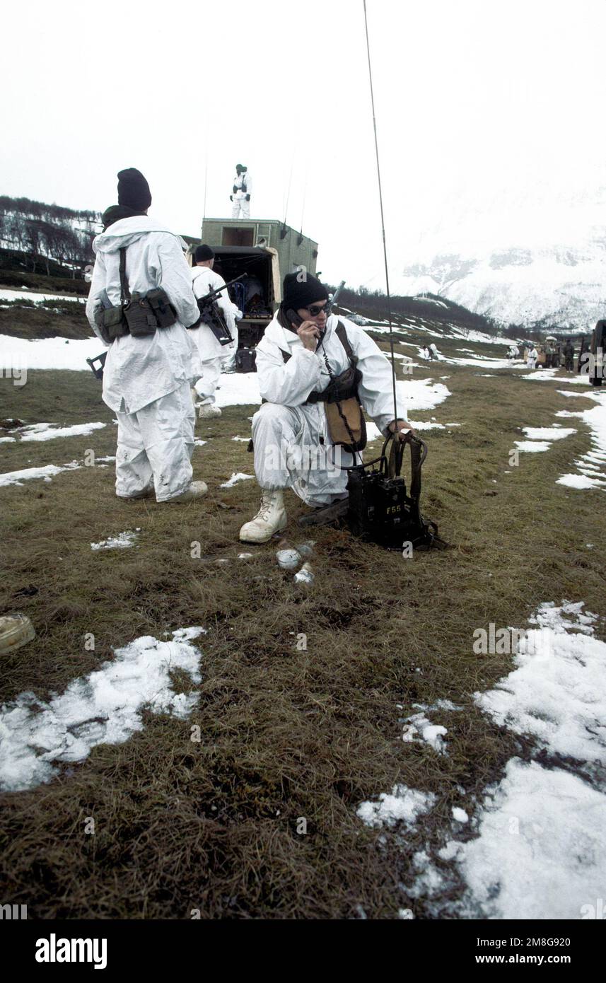 U.S. Marines in snow camouflage use communications gear to guide ...