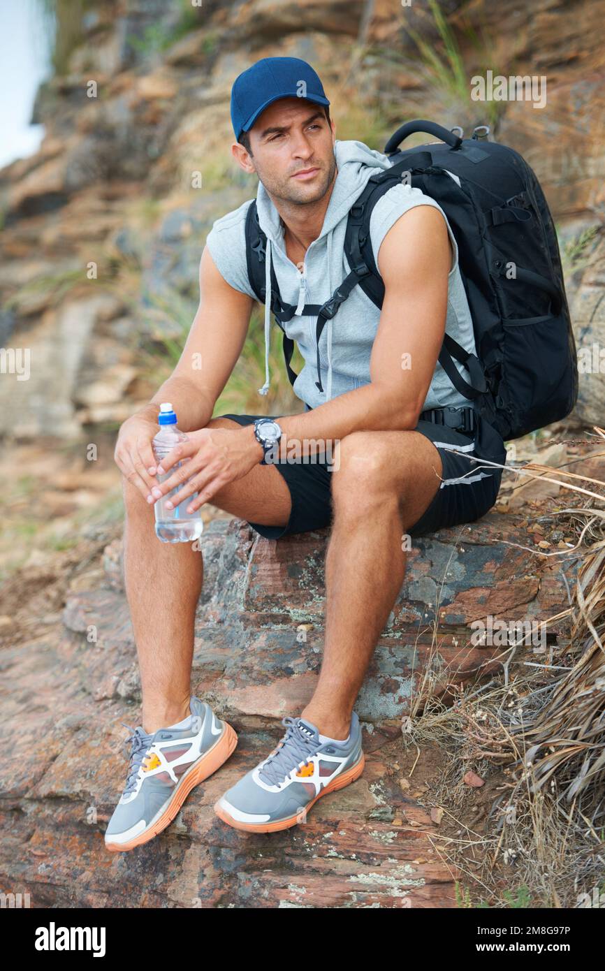 Taking a moment to appreciate the view. Handsome young hiker taking a ...