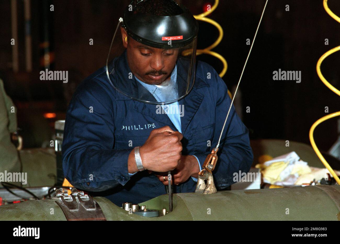 A mineman installs a firing mechanism on a Mark 64 Quickstrike mine ...