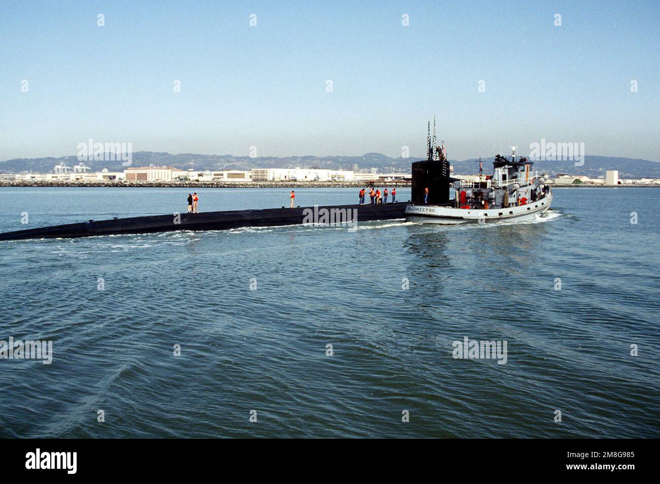 The large harbor tug POUGHKEEPSIE (YTB-813) escorts the nuclear-powered ...