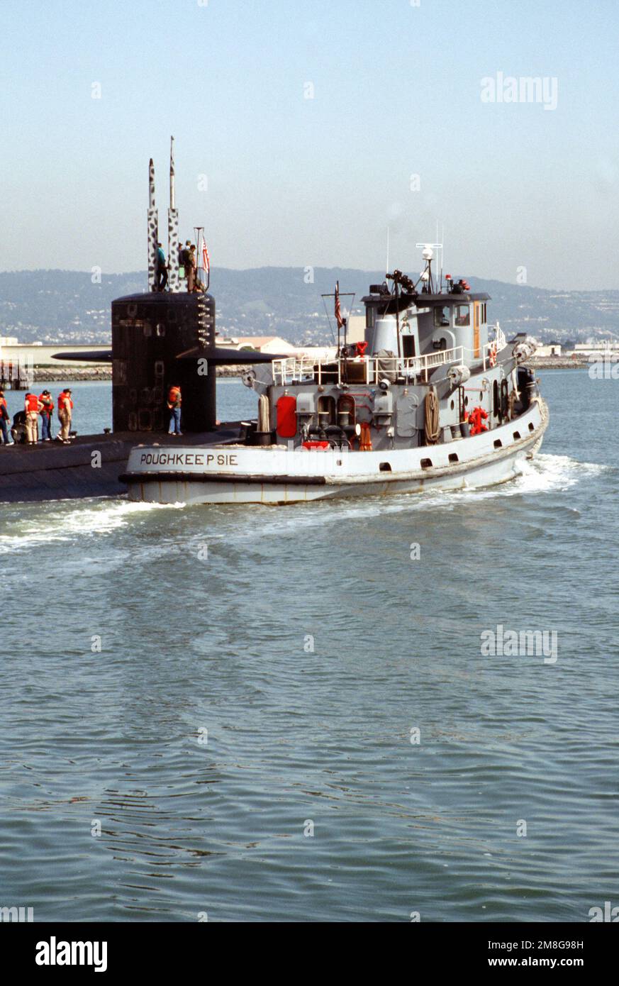 The large harbor tug POUGHKEEPSIE (YTB-813) escorts the nuclear-powered ...