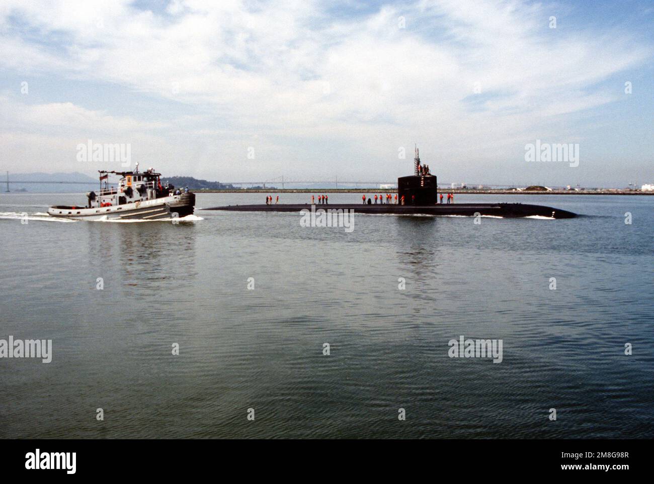 Crew members stand on deck aboard the nuclear-powered submarine USS ...