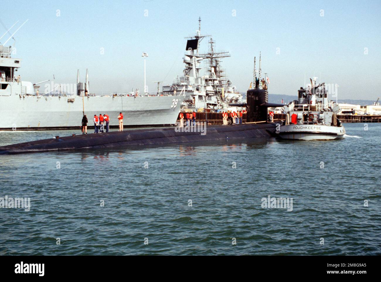 Crew members stand on deck aboard the nuclear-powered submarine USS LOUISVILLE (SSN-724) as the ...
