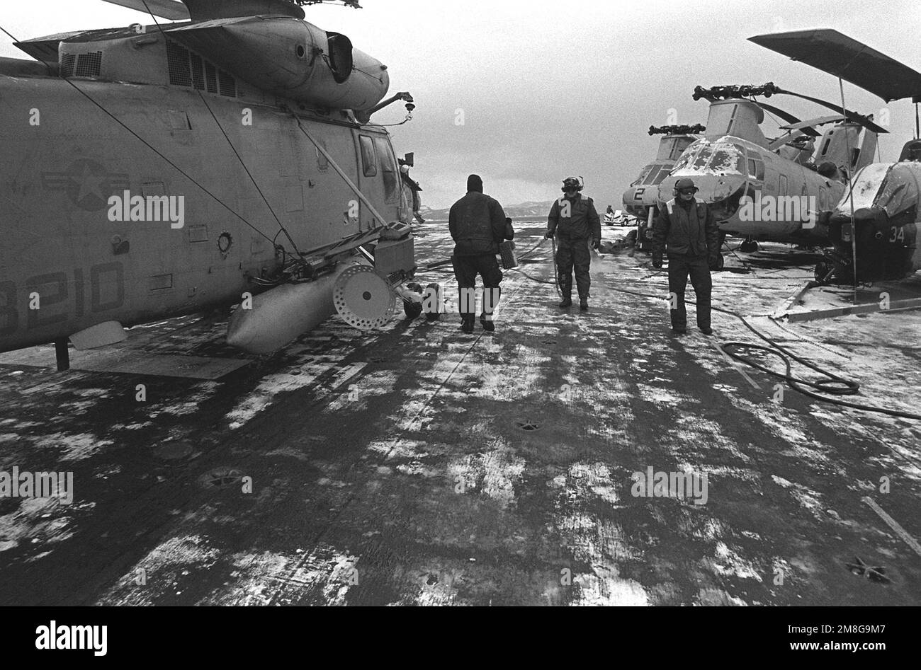 Flight deck personnel prepare a SH-2F Sea Sprite helicopter for launch ...