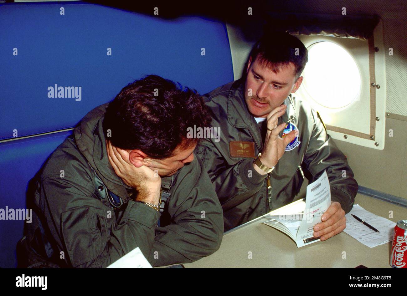 LT Tim Ovening and LCDR Latta discuss training procedures aboard a P-3C ...