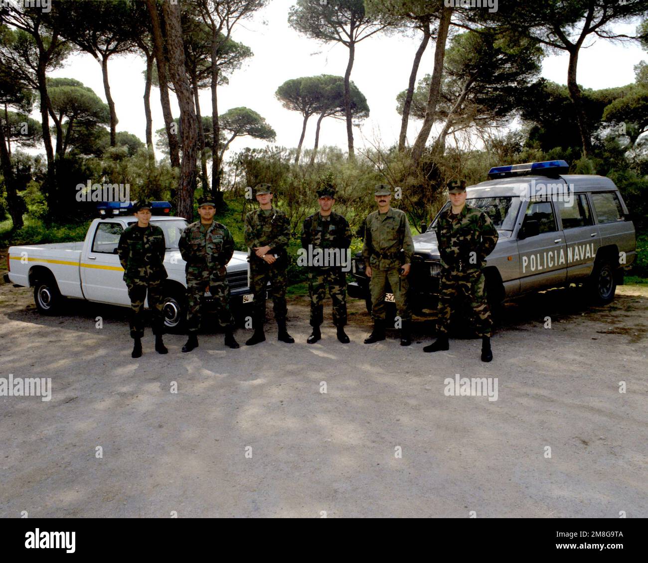 A group of Spanish and U.S. naval police in front of their vehicles ...