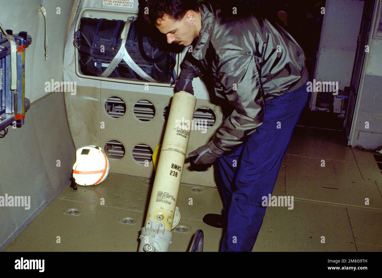 A member of Patrol Squadron 31 (VP-31) prepares to load a sonobuoy into ...