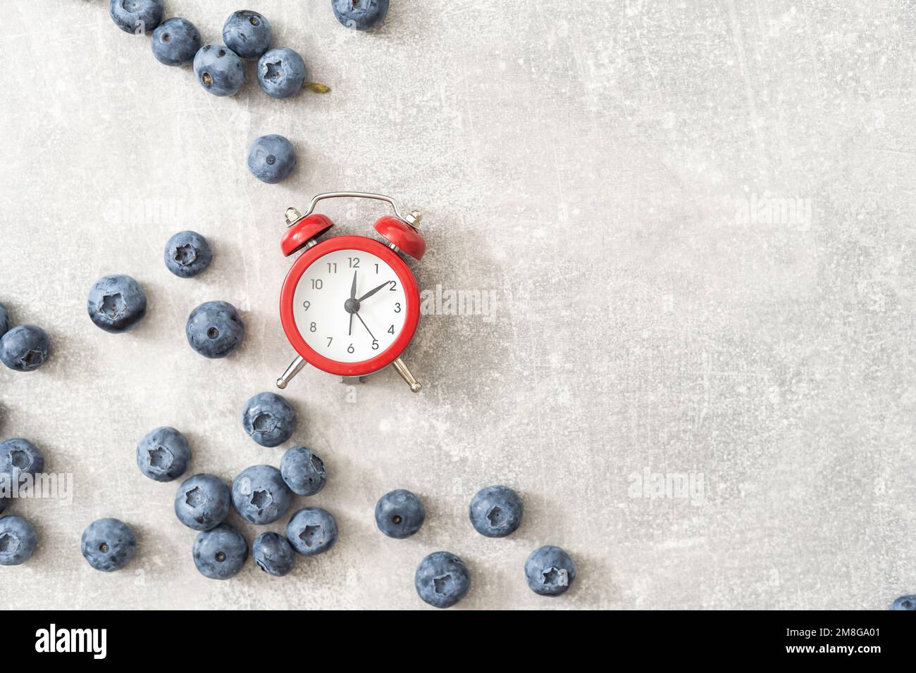 vintage alarm clock on blueberry background Stock Photo - Alamy