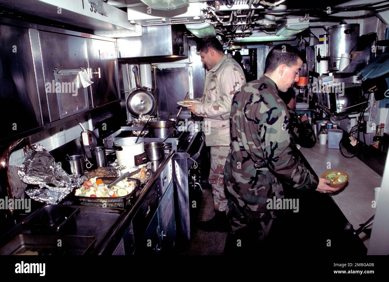 Crew members aboard utility landing craft find time to prepare a meal ...