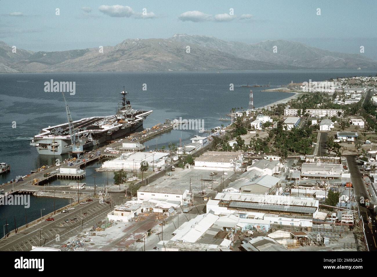 The aircraft carrier USS INDEPENDENCE (CV-62) stands moored to a pier ...