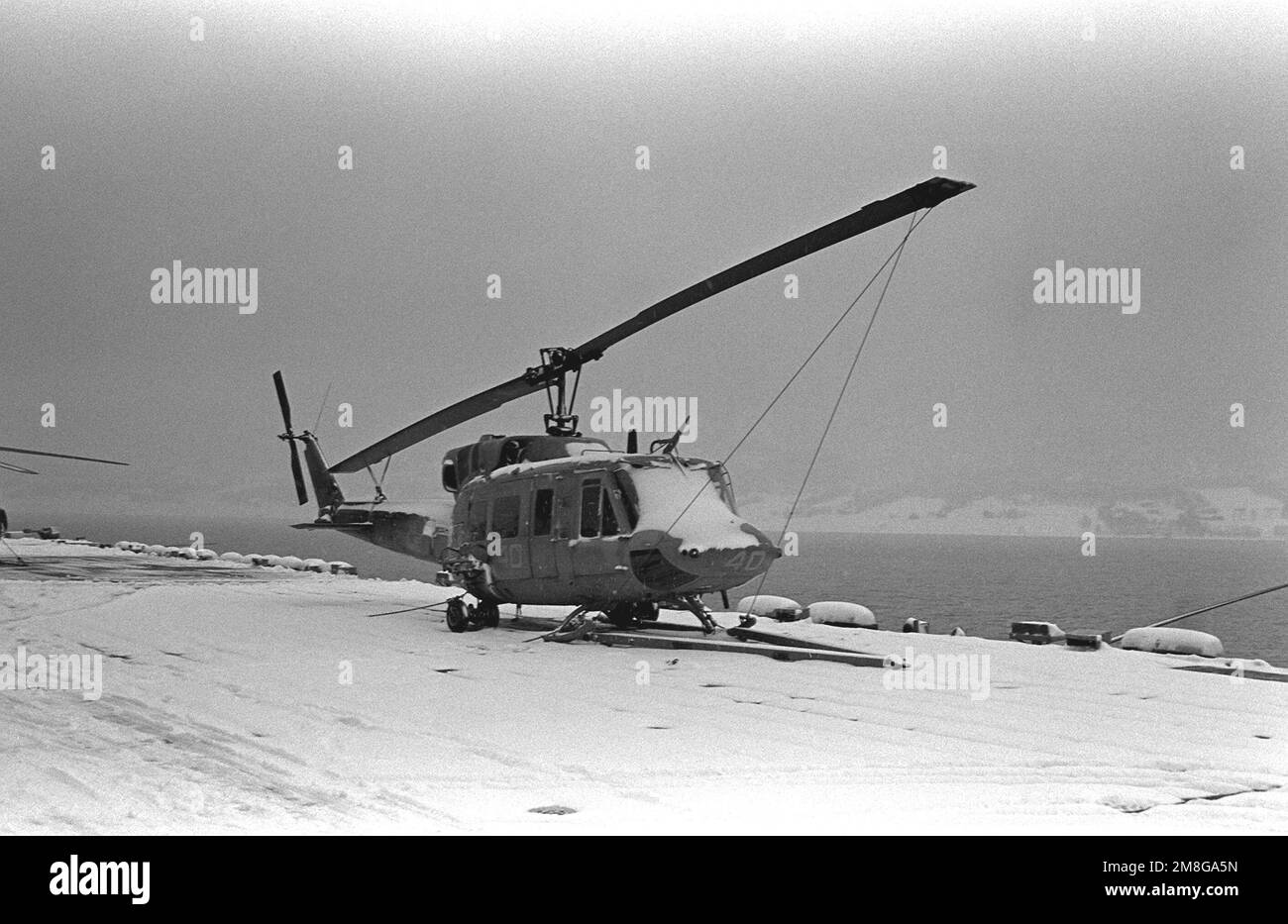 A UH-1N Iroquois "Huey" helicopter sits on the flight deck of the ...