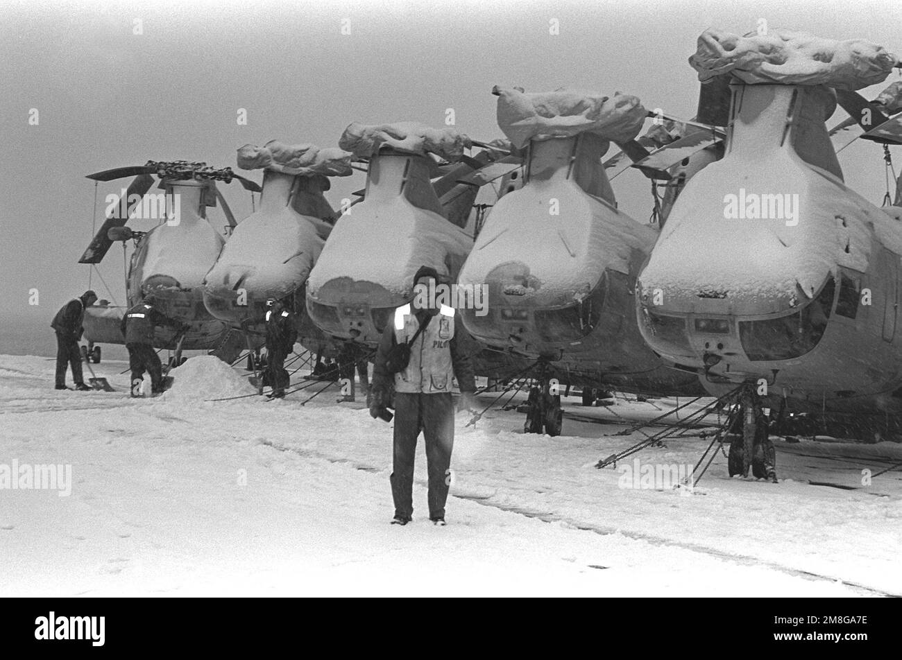 Sailors once again start to shovel snow clear of the CH-46E Sea Knight ...