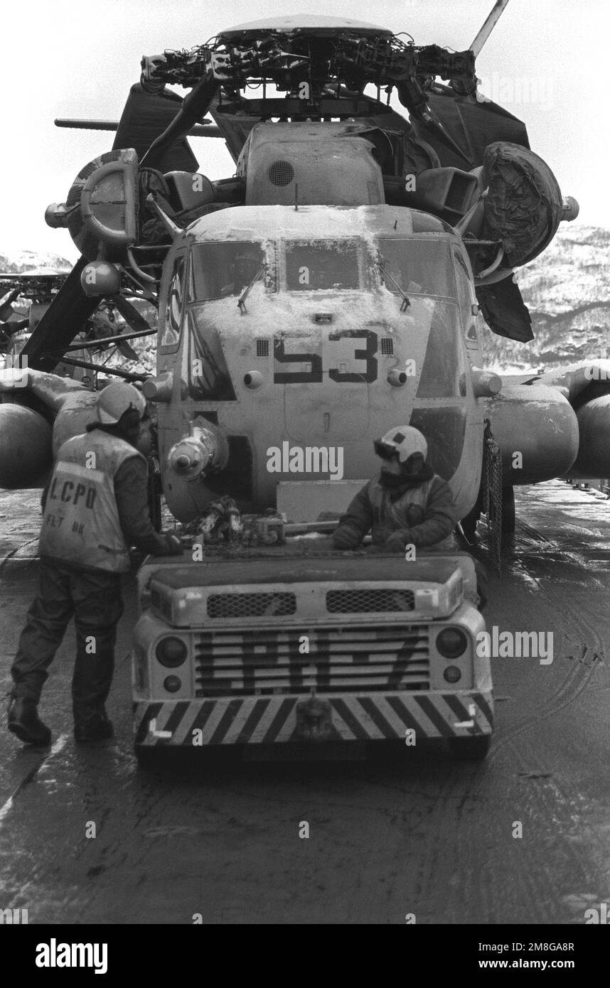 Flight deck crewmen use an M-3D tow tractor to respot a CH-53E Super ...