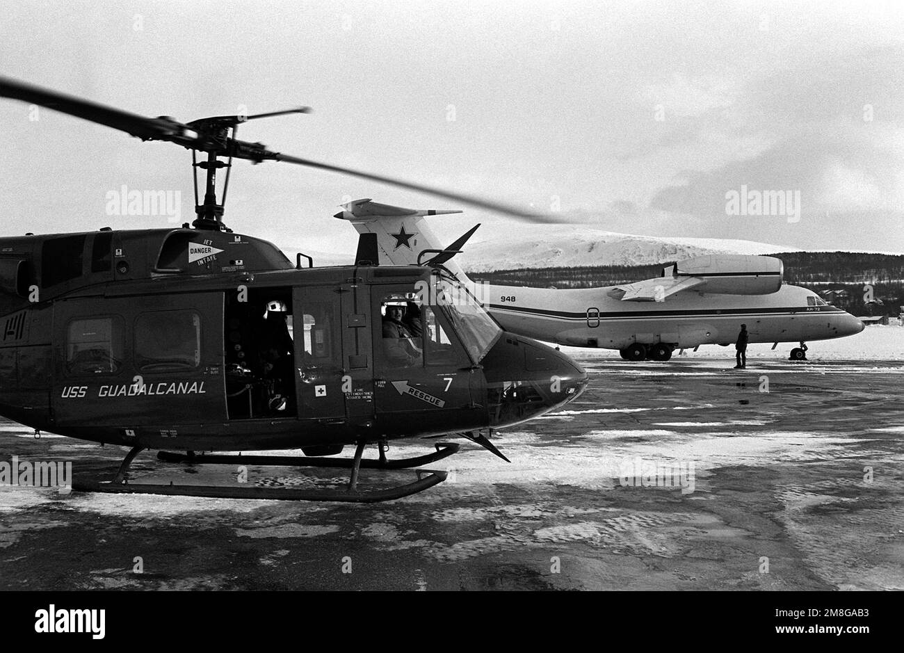 A Russian AN-72 Coaler aircraft parked on the tarmac behind the UH-1N ...